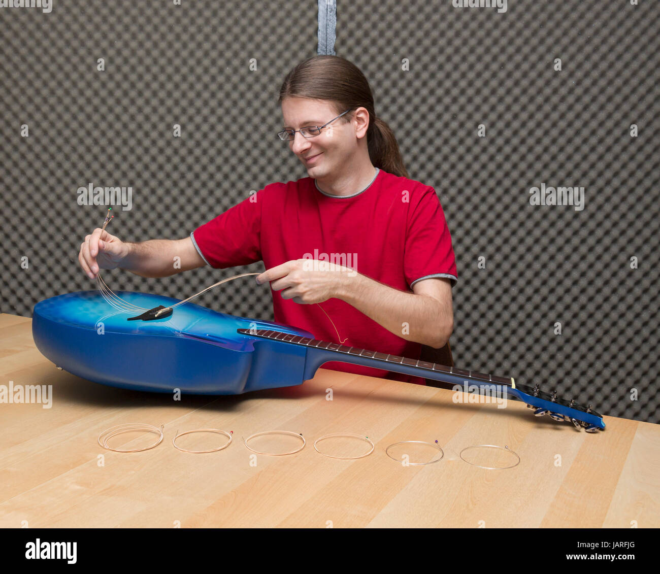 Guitarist pulling the old strings of a guitar out ( Series with the ...