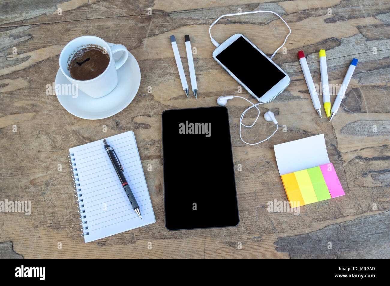 Digital tablet with sticky note paper, pens, smart phone, notebook and ...