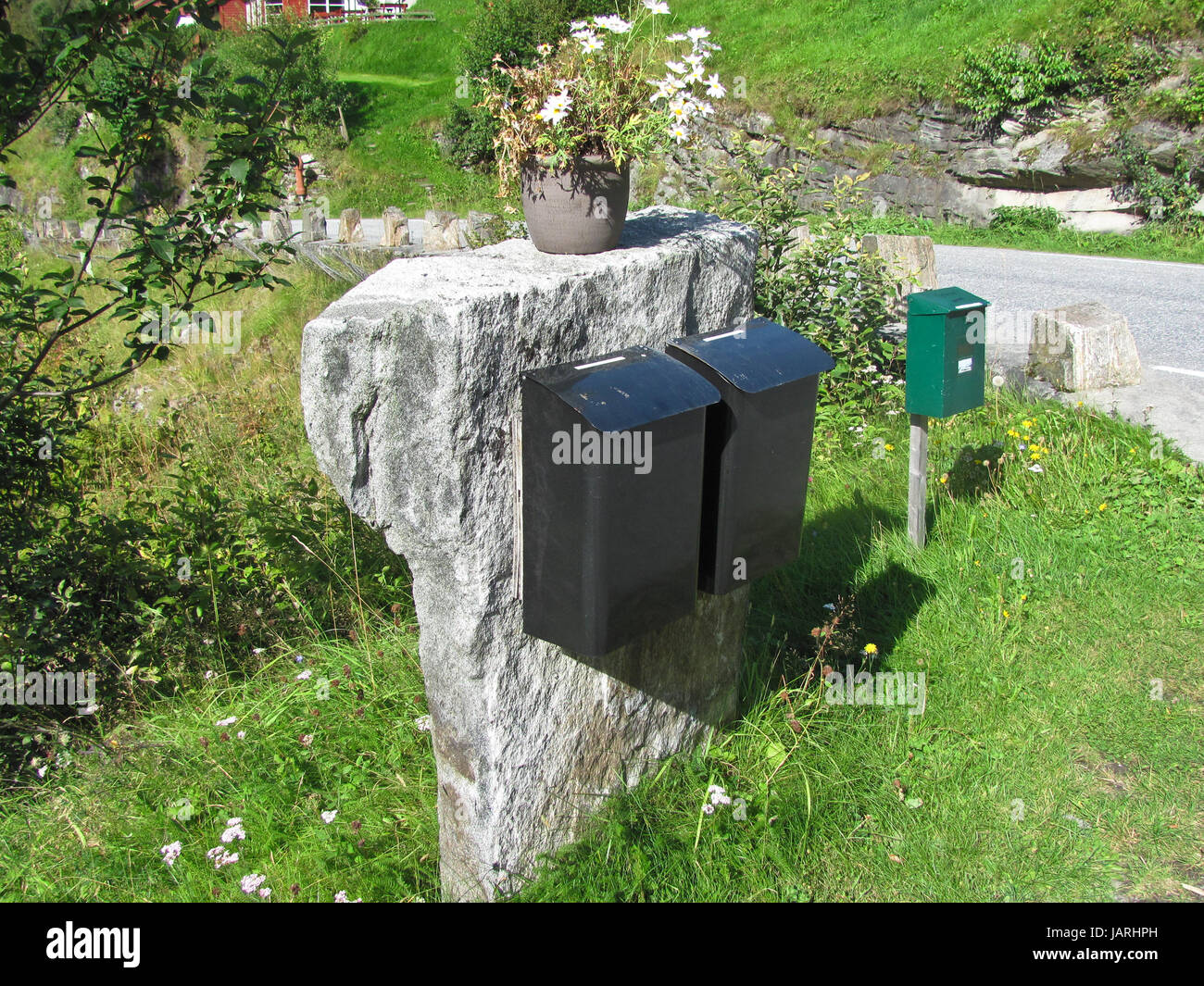 Mailboxes on a rock, next to a trash can Stock Photo - Alamy
