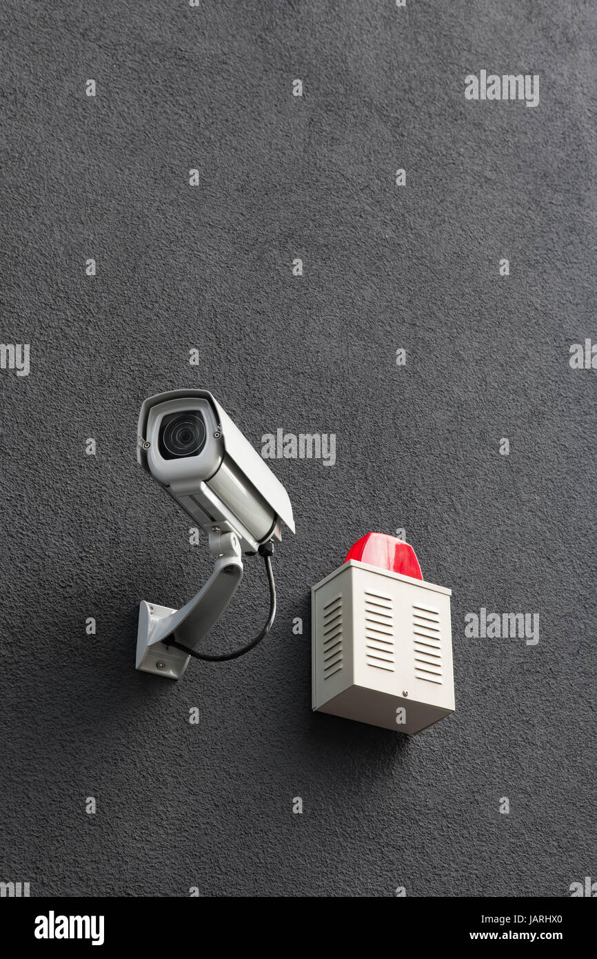 White security camera system on a wall Stock Photo - Alamy