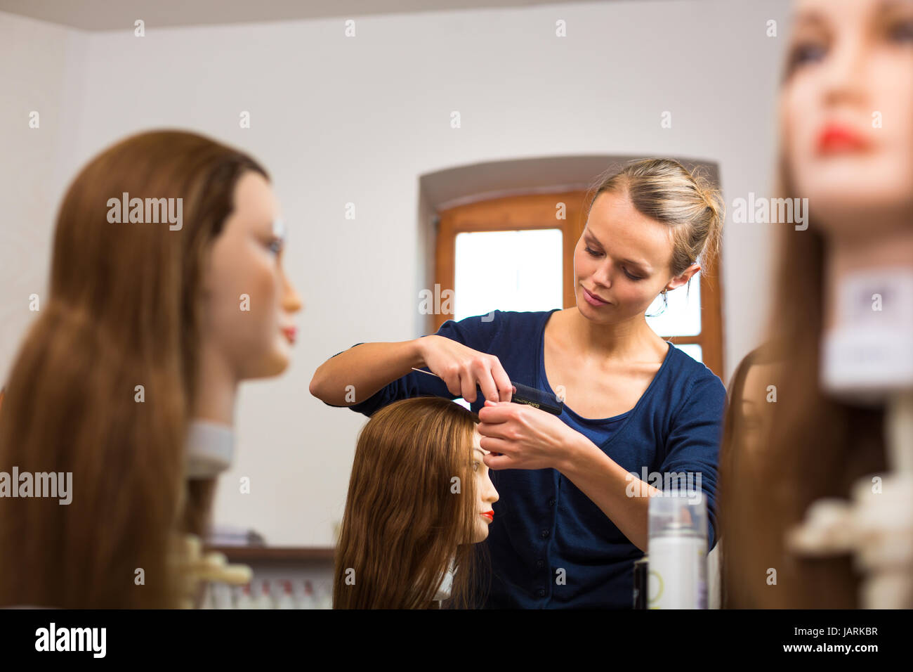 Pretty female hairdresser/haidressing apprentice/student training on an ...