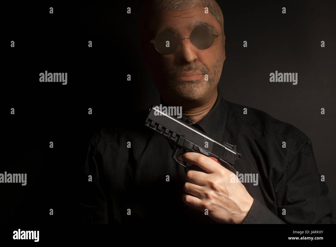 criminal bandit man wearing a stocking mask holds a gun in his hand on ...