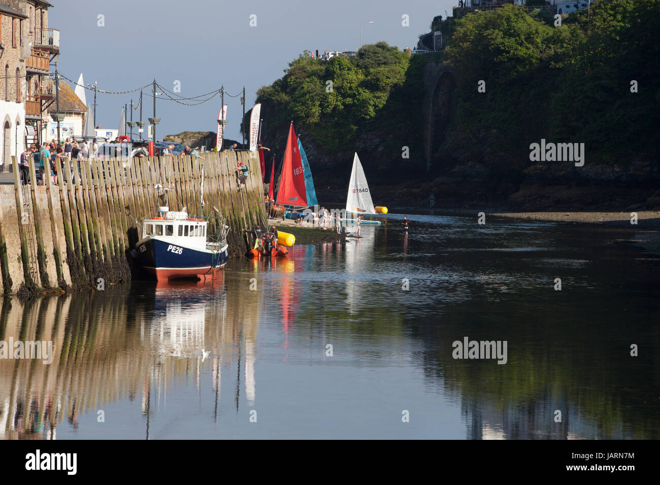 Dinghies with colourful sails launch from the slip on the river at Looe ...