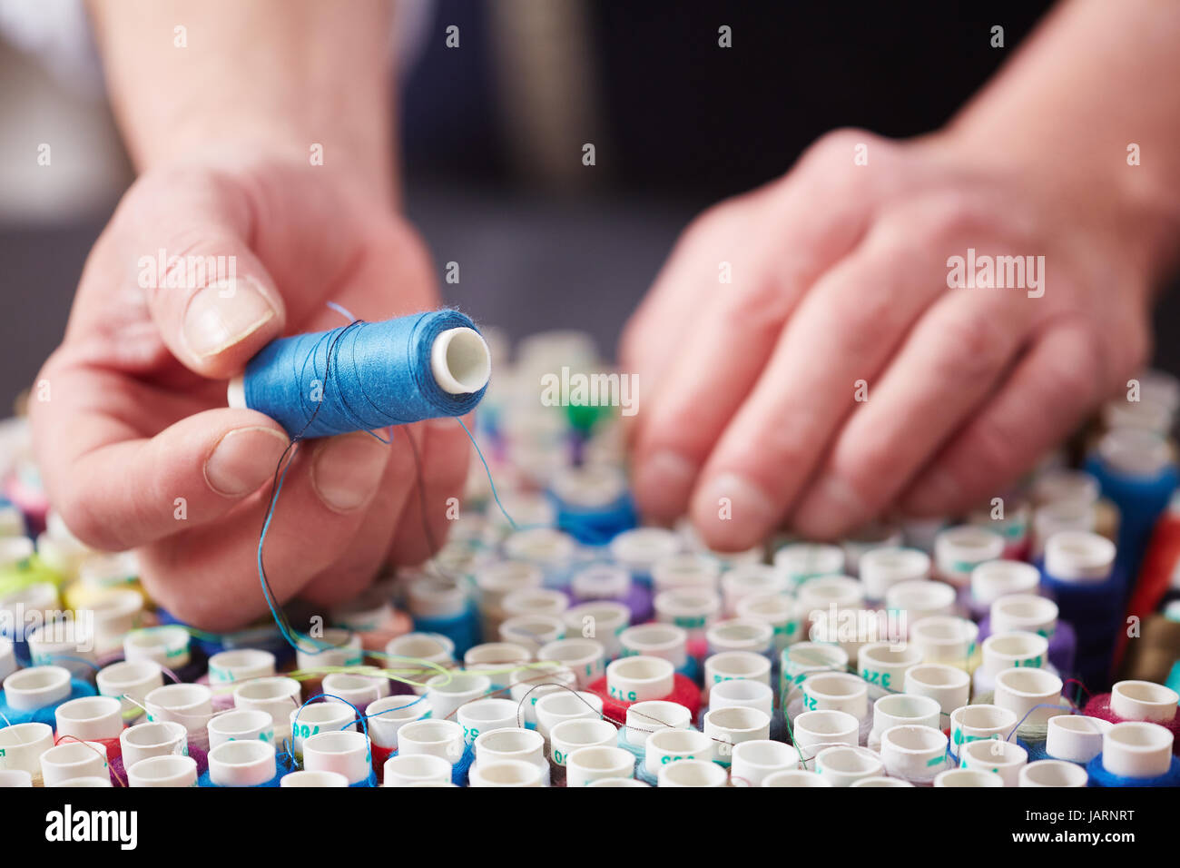 Tailor Choosing Blue Thread Stock Photo - Alamy