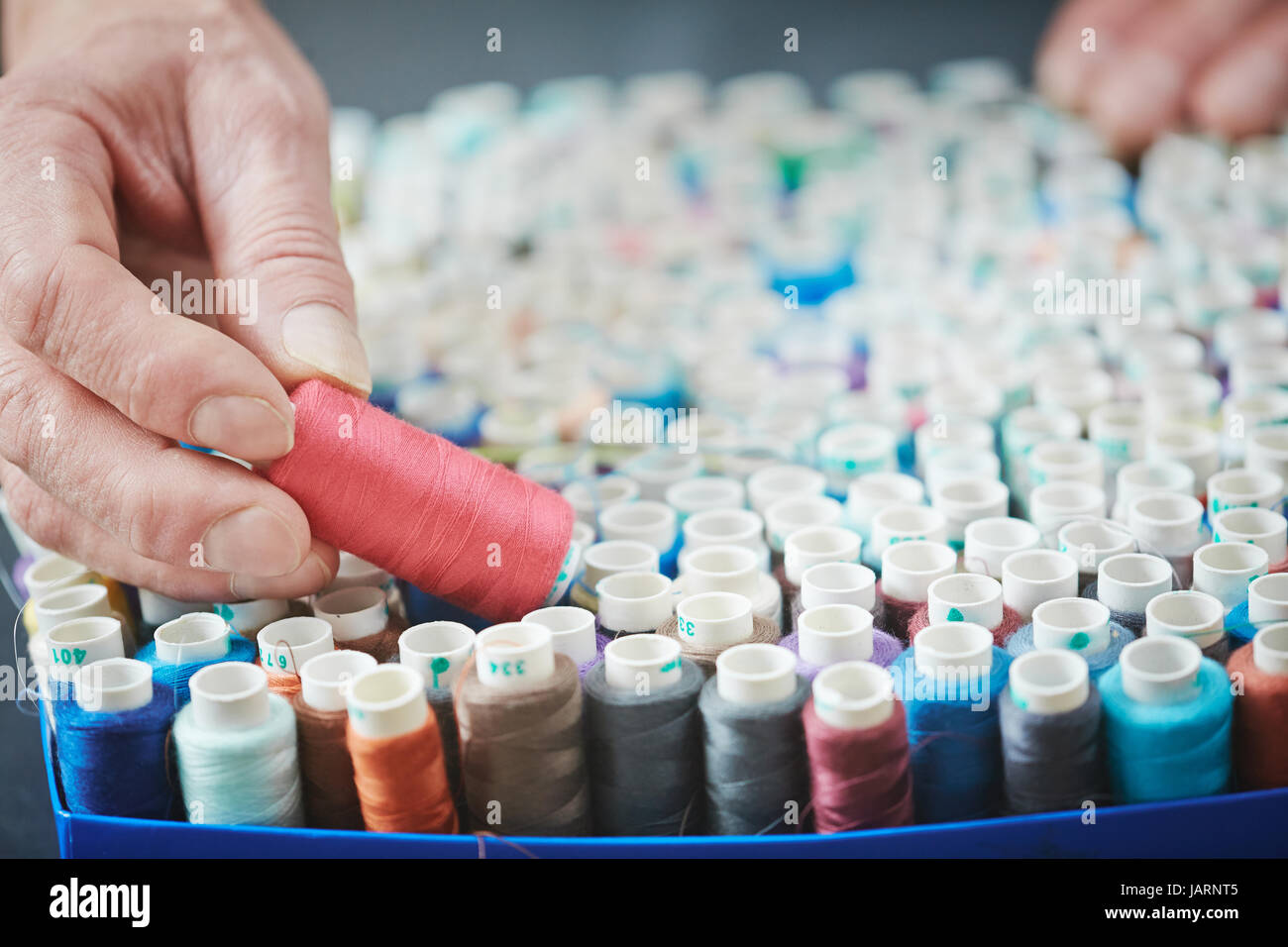 Tailor Choosing Sewing Spools in Atelier Stock Photo - Alamy