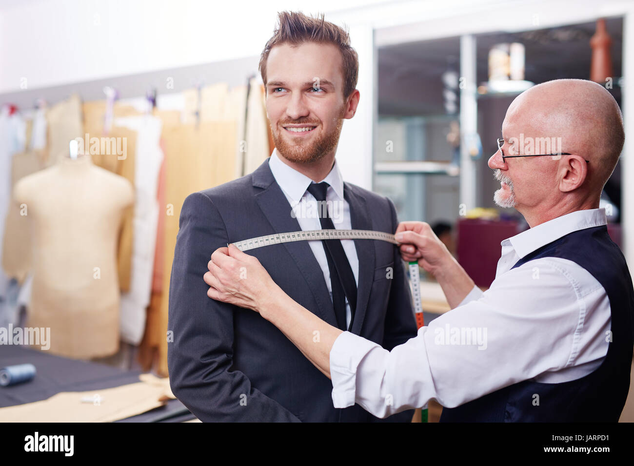 Tailor Measuring Smiling Client in Atelier Stock Photo - Alamy
