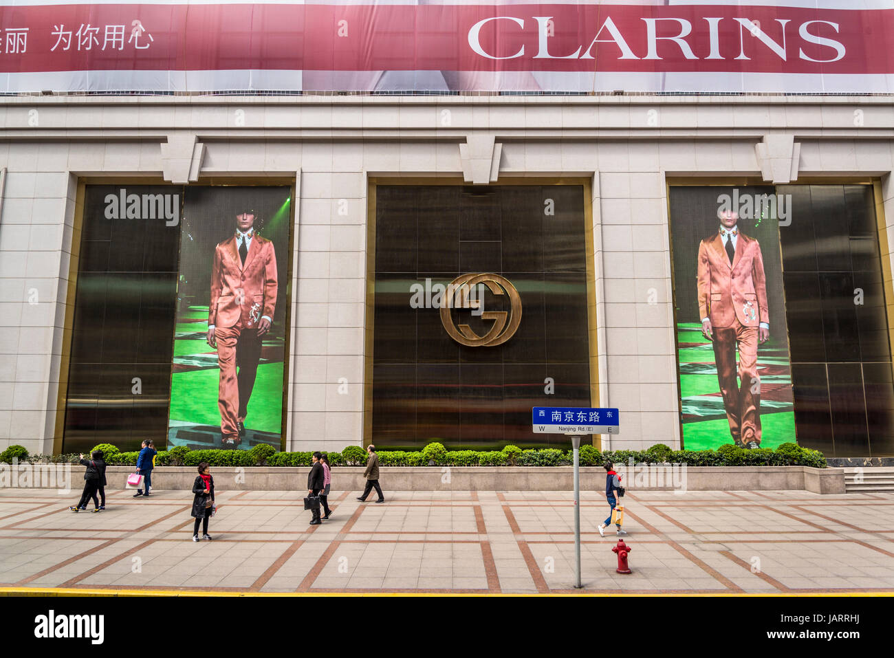 Huge advertising moving image hoarding towering over pedestrians in ...