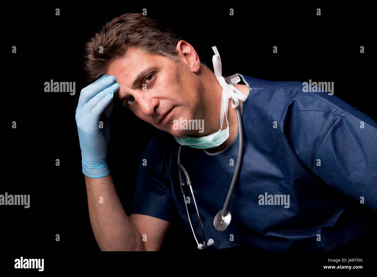 Tired doctor in uniform isolated against a black background Stock Photo ...
