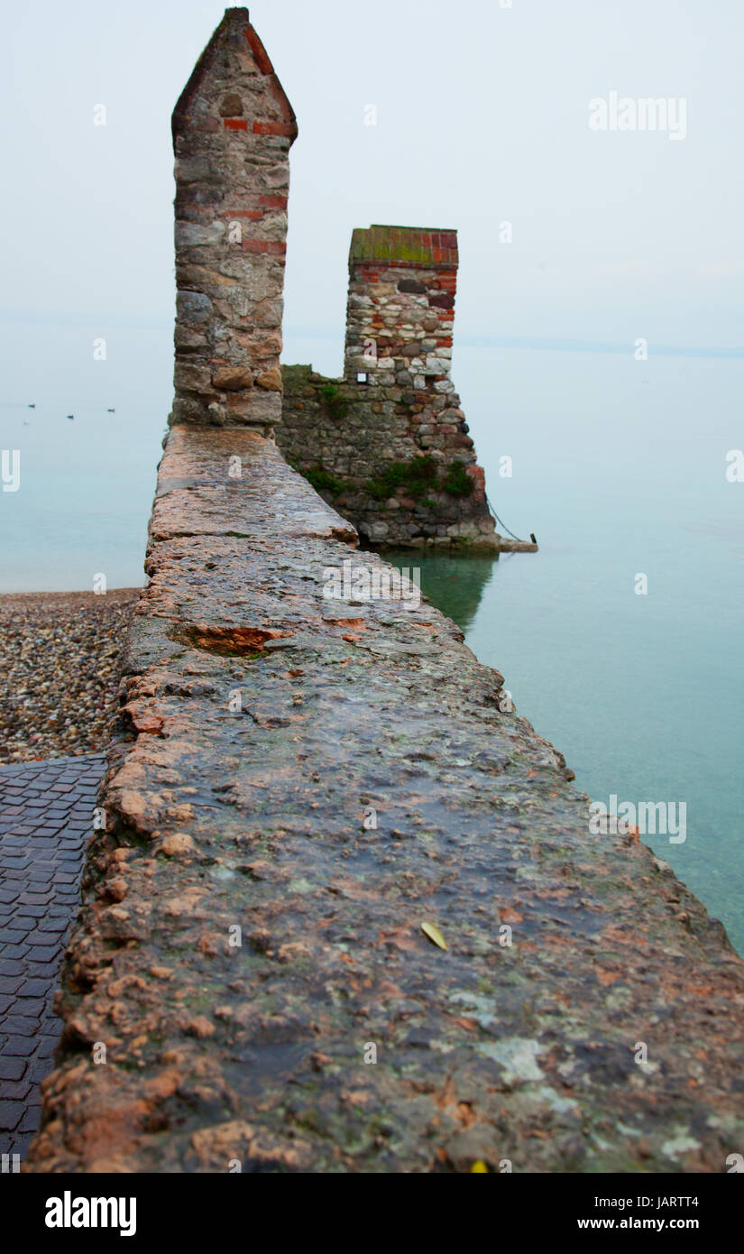 A castle wall extending over the lake Stock Photo - Alamy