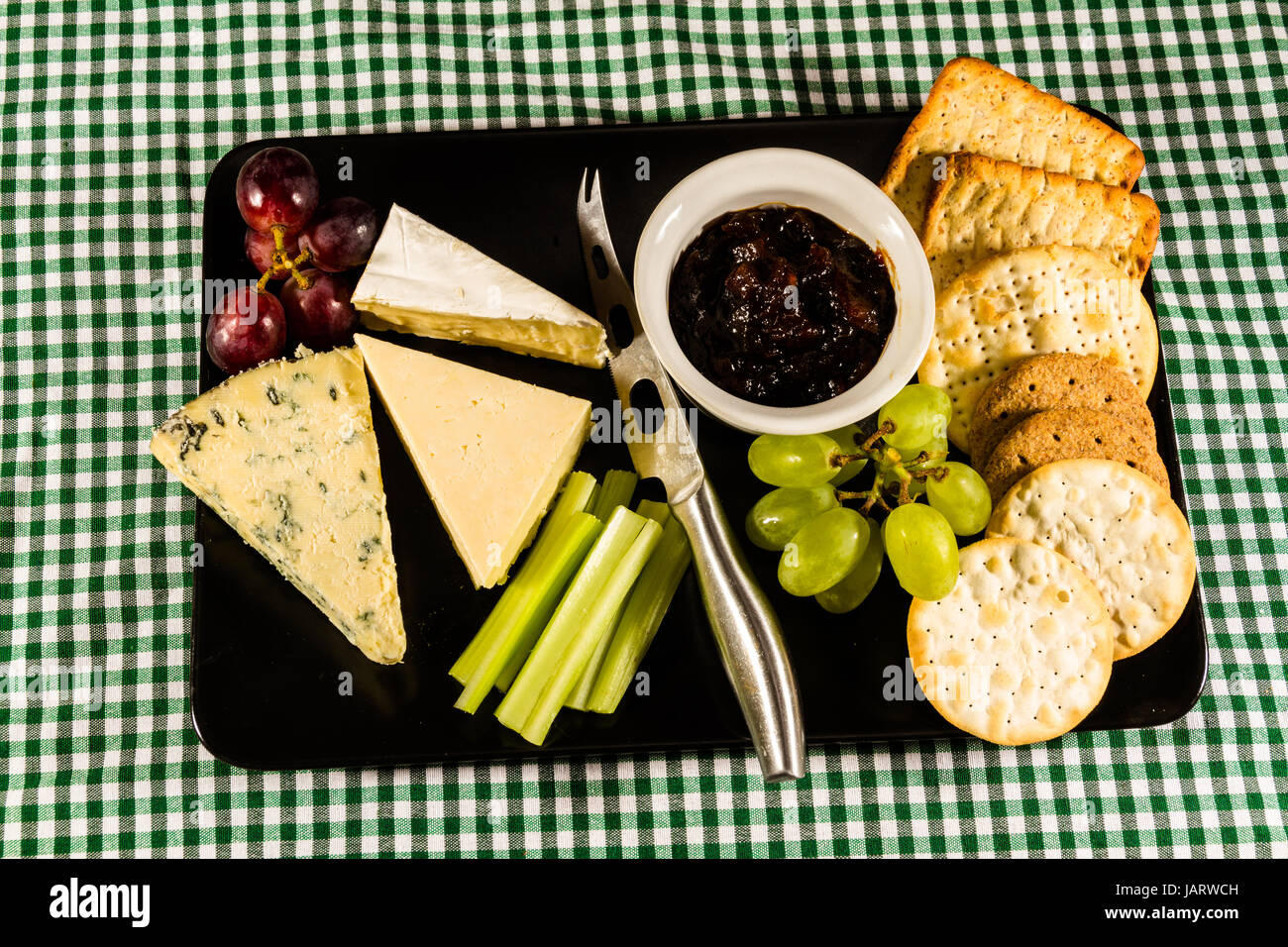 Large cheeseboard with brie, cheddar, stilton, grapes, red onion ...