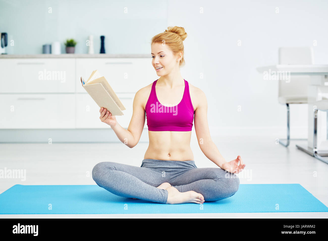 Smiling Yogi Woman Reading Book Stock Photo - Alamy