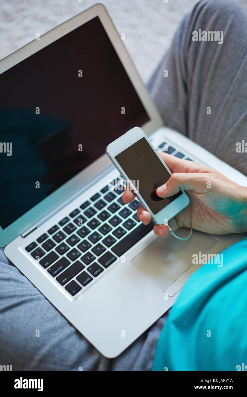 Modern man with smartphone and laptop Stock Photo - Alamy