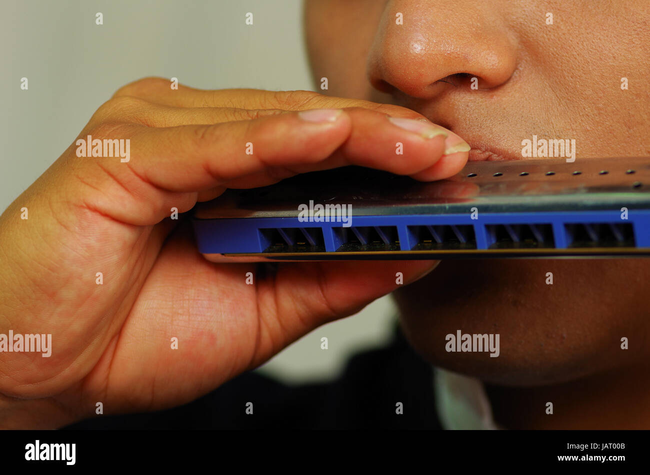 Close up portrait of young indigenous man playing the harmonica Stock ...