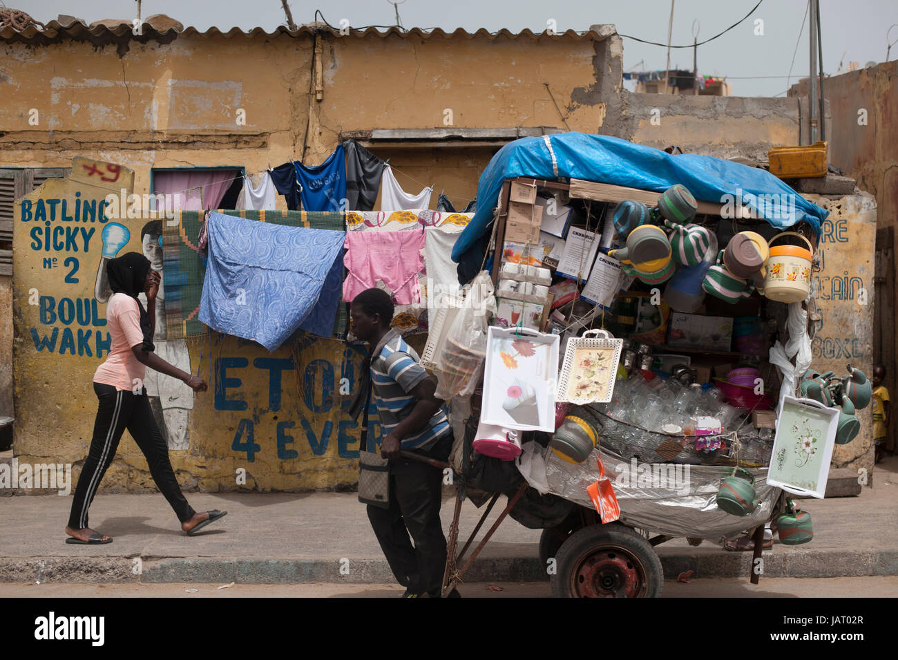 man pulling a hand cart full of daily hardware items for sale in the ...