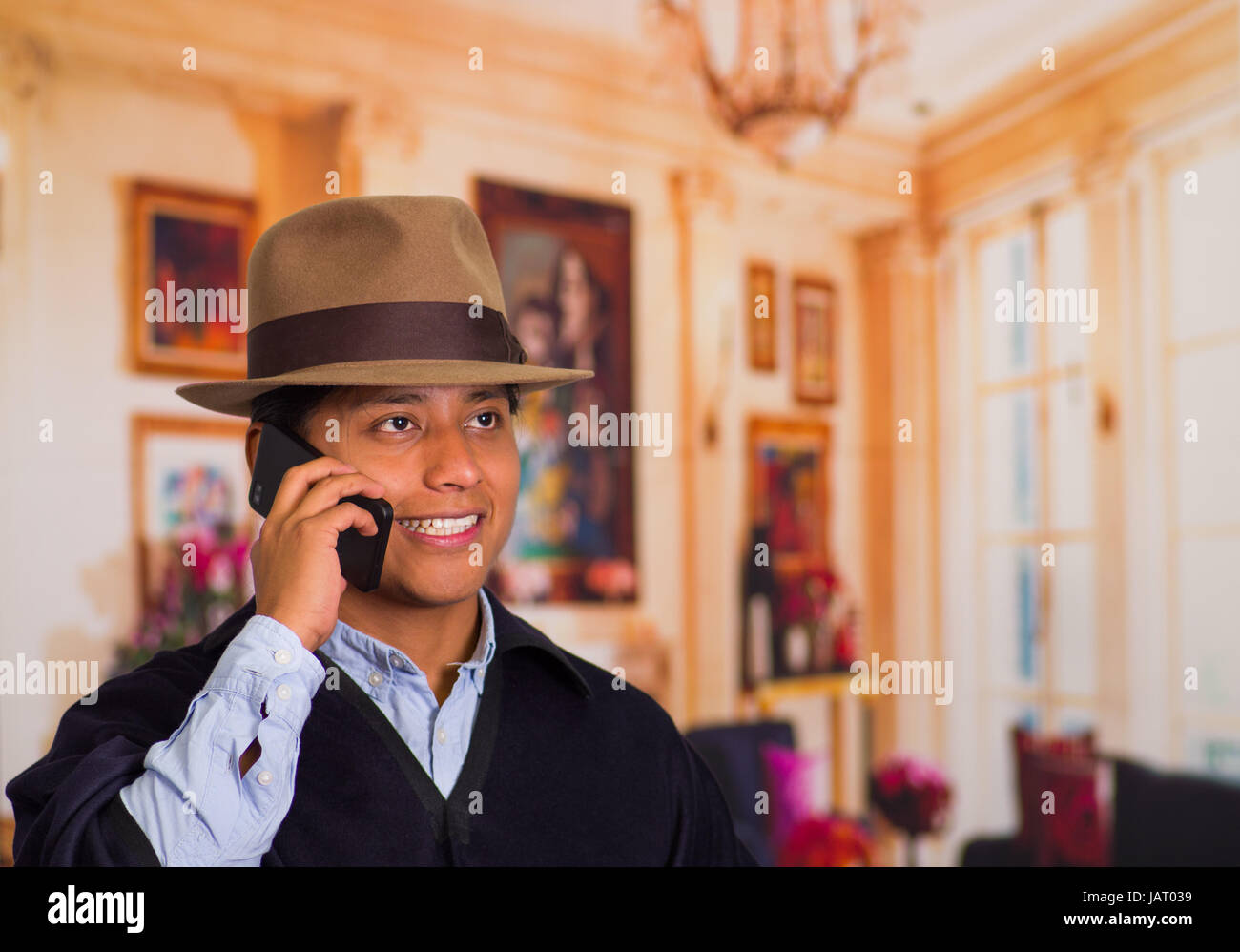 Close up portrait of smiling young indigenous man wearing hat and ...
