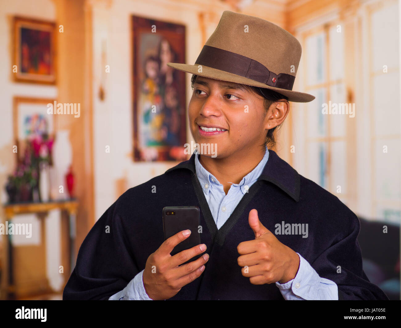 Close up portrait of smiling handsome young indigenous man wearing hat ...