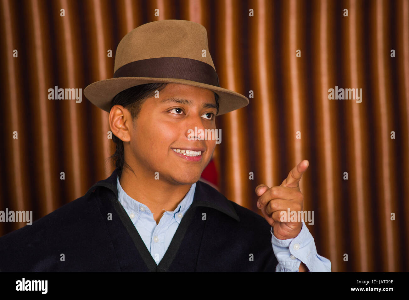Close up portrait of happy indigenous young man wearing traditional hat ...