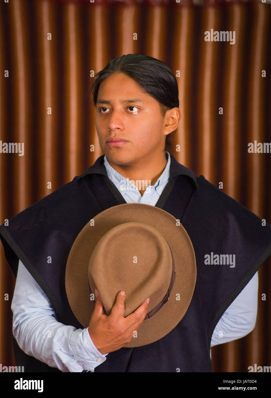 Close up portrait of young indigenous latin american man holding his ...