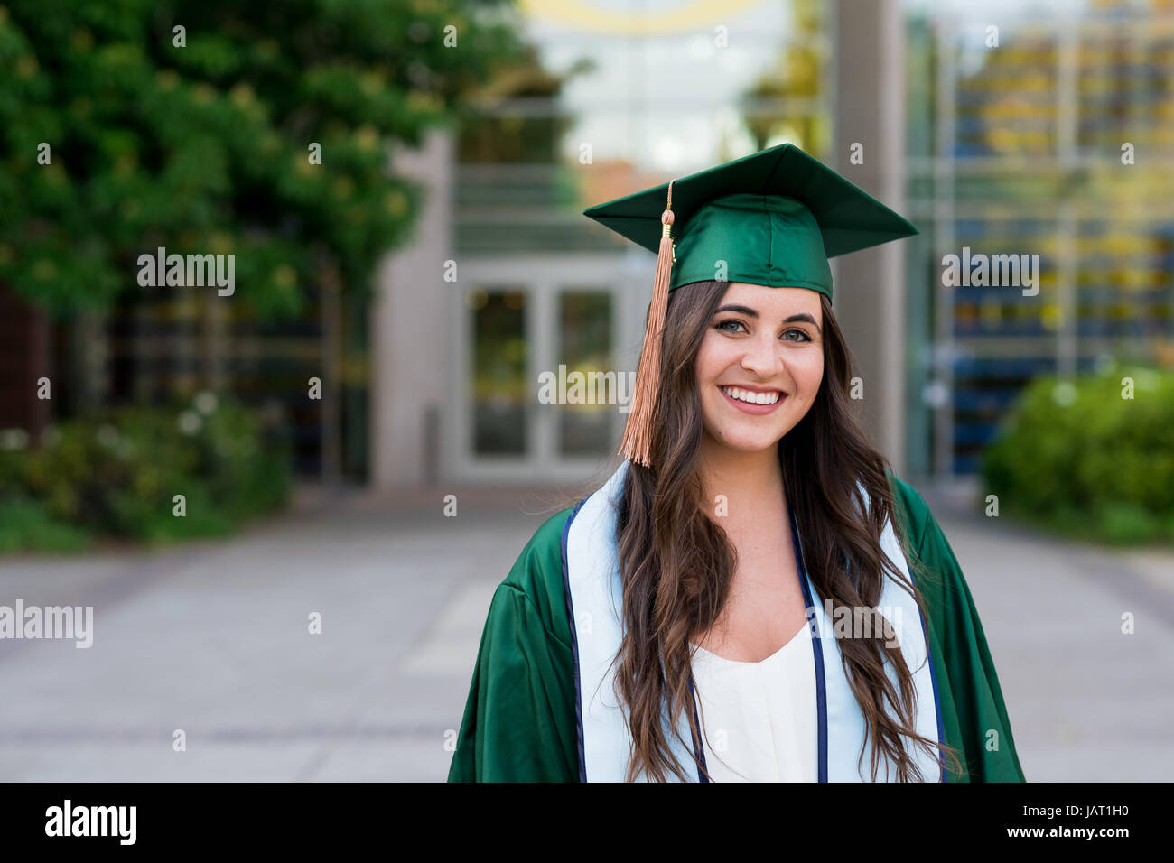 Pretty girl posing for a graduation photo on campus during her senior ...