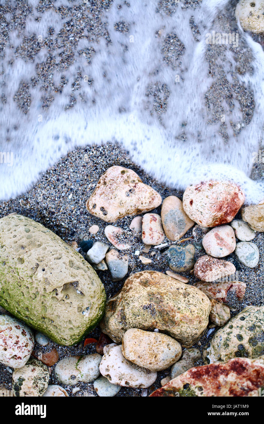 Color shot of some stones being washed by a wave Stock Photo - Alamy