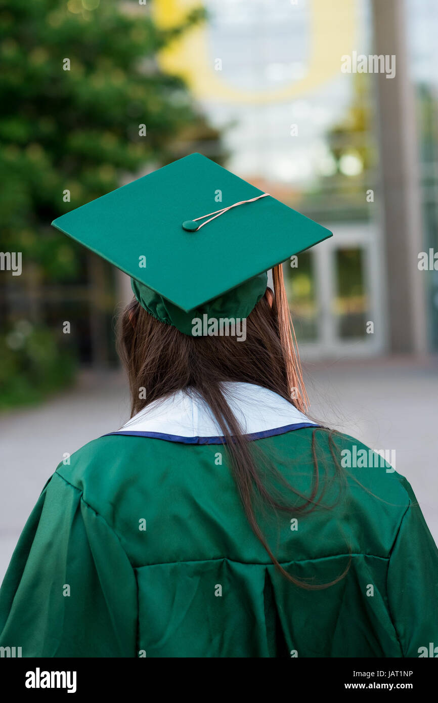 Pretty girl posing for a graduation photo on campus during her senior ...