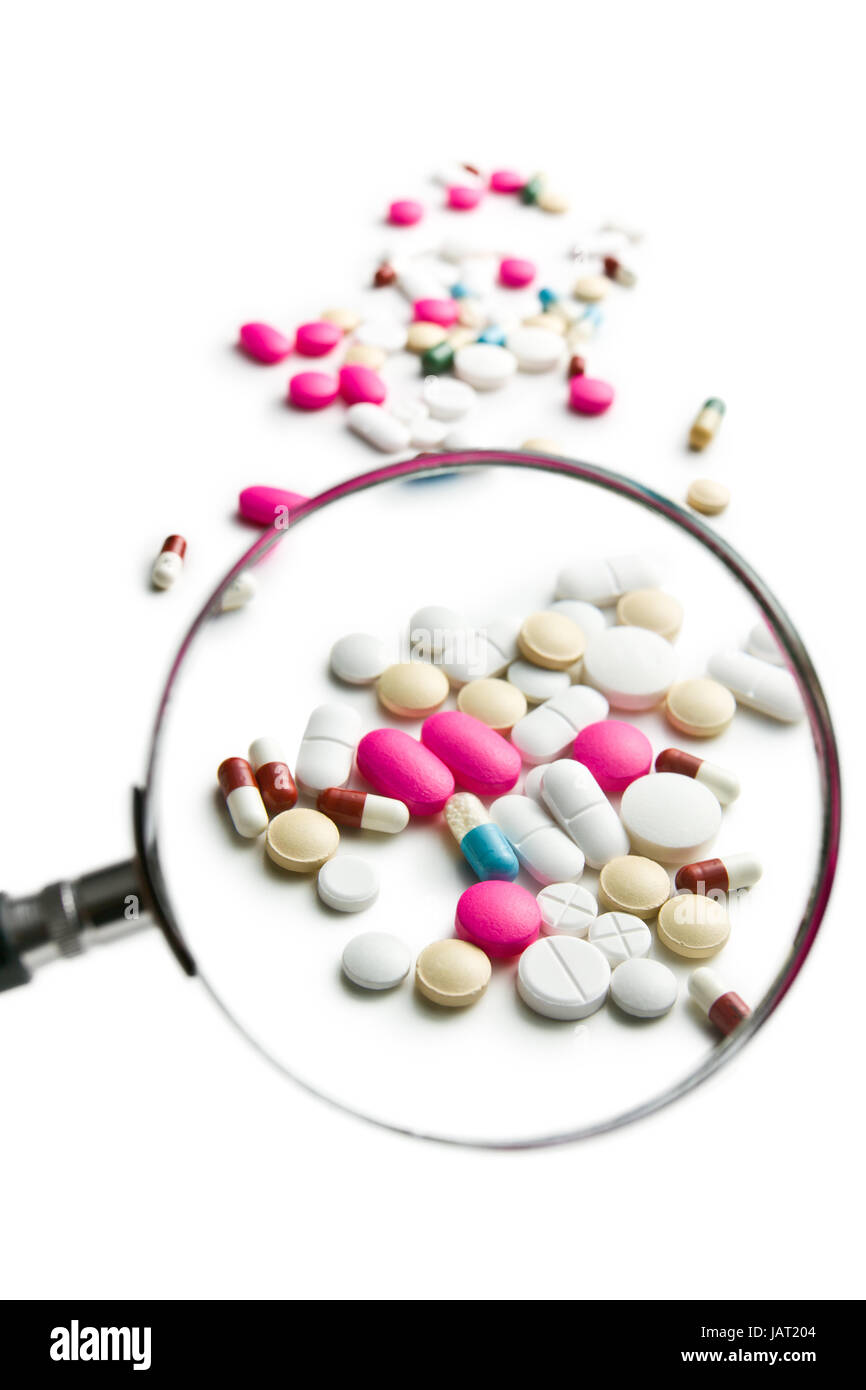 pills under magnifying glass on white background Stock Photo - Alamy
