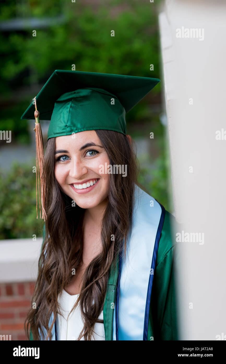 Pretty girl posing for a graduation photo on campus during her senior ...