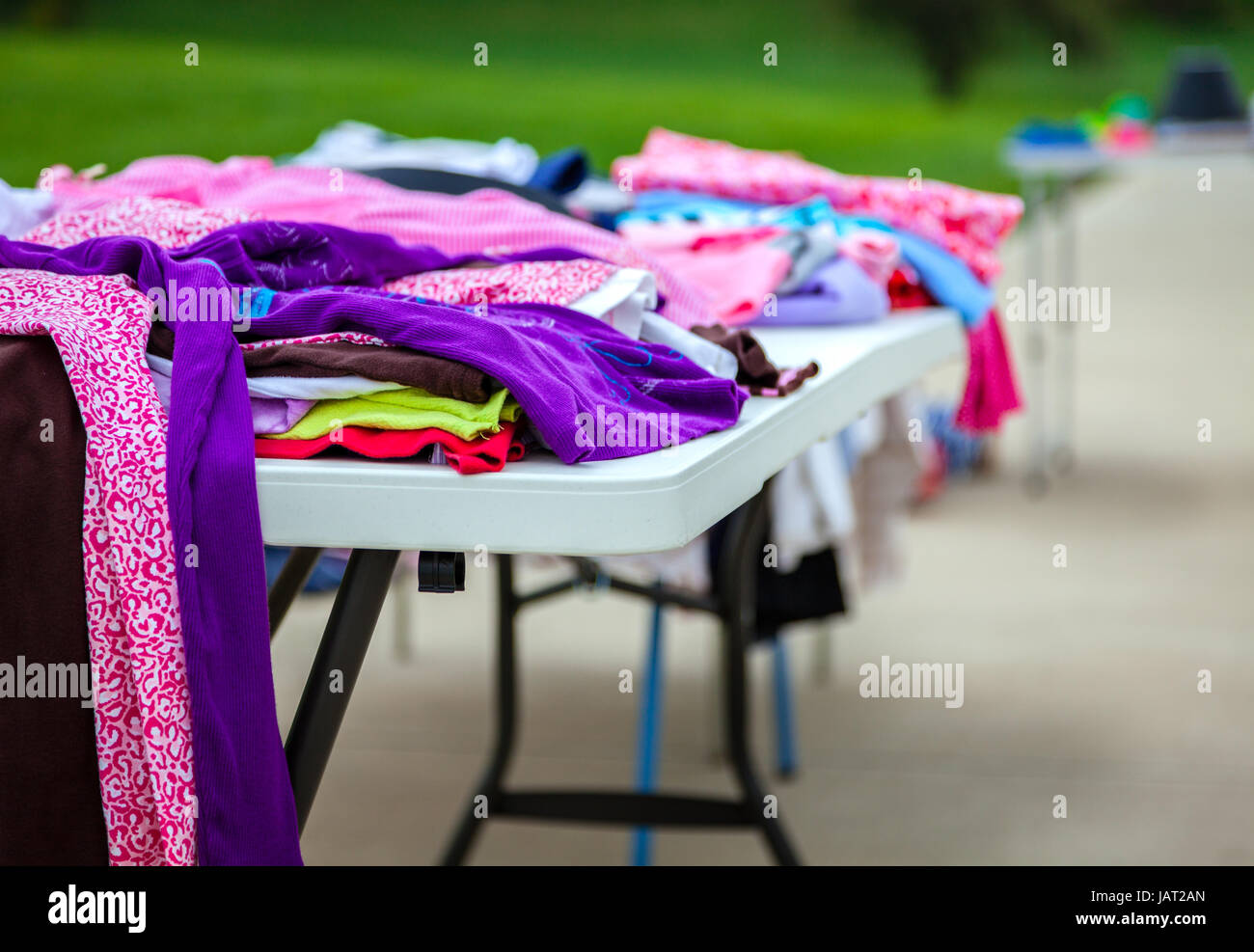 Clothes laid out on a table at a garage sale Stock Photo - Alamy