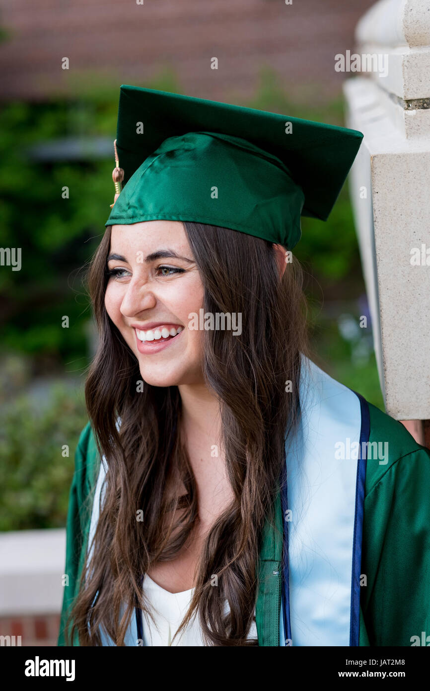 Pretty girl posing for a graduation photo on campus during her senior ...