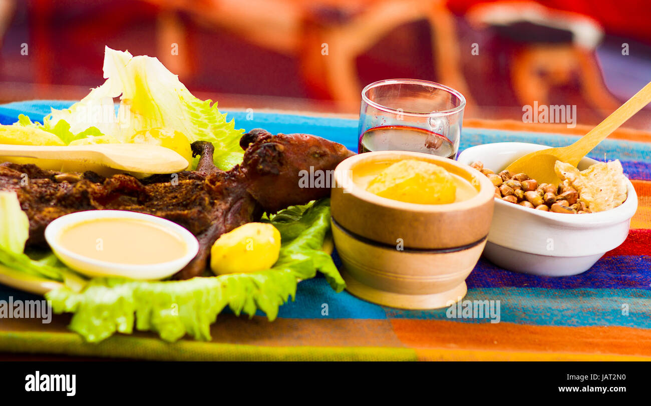 Traditional ecuadorian dish, grilled guinea pig spread out onto green ...