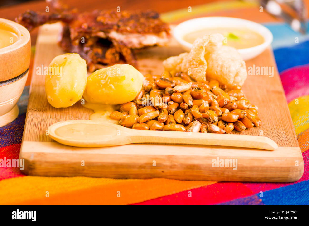 Cut pieces cooked guine pig meat lying on wooden surface next to ...