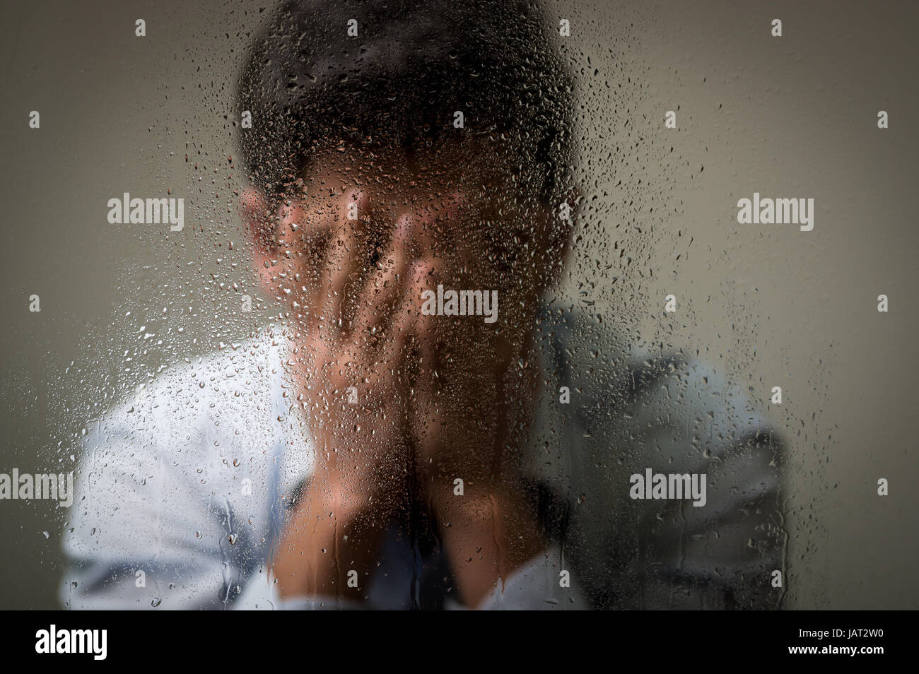 Worry depresed young man, hiding from camera using his hands, behind a ...