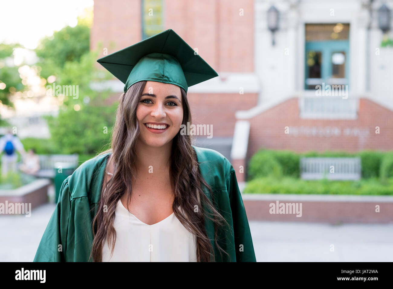 Pretty girl posing for a graduation photo on campus during her senior ...