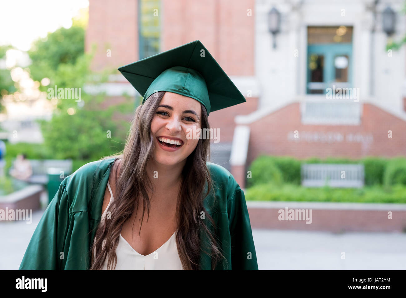 Pretty girl posing for a graduation photo on campus during her senior ...