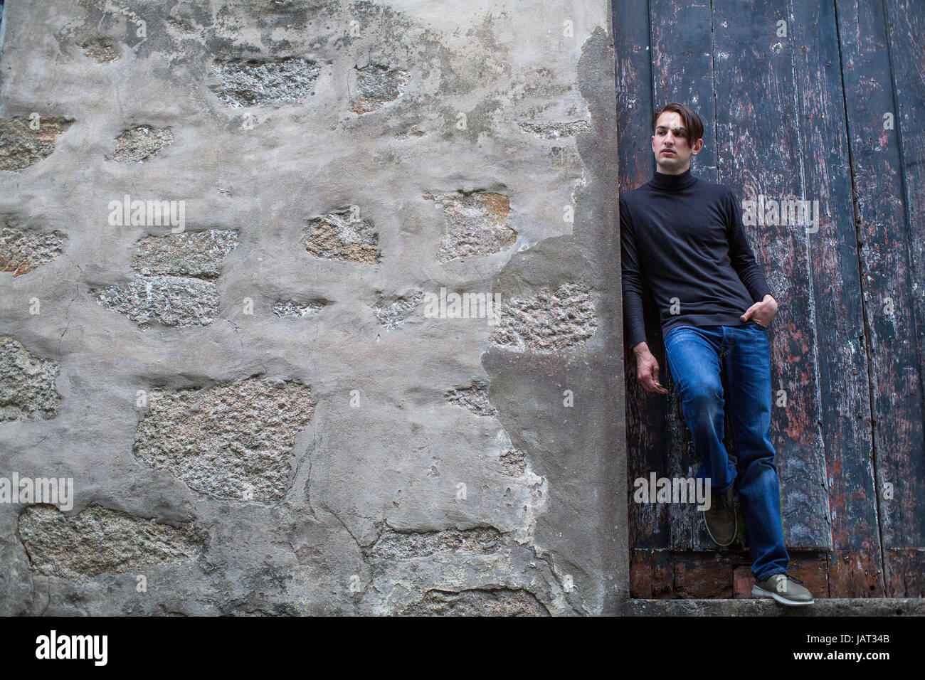Young handsome man standing leaning on the wall Stock Photo - Alamy