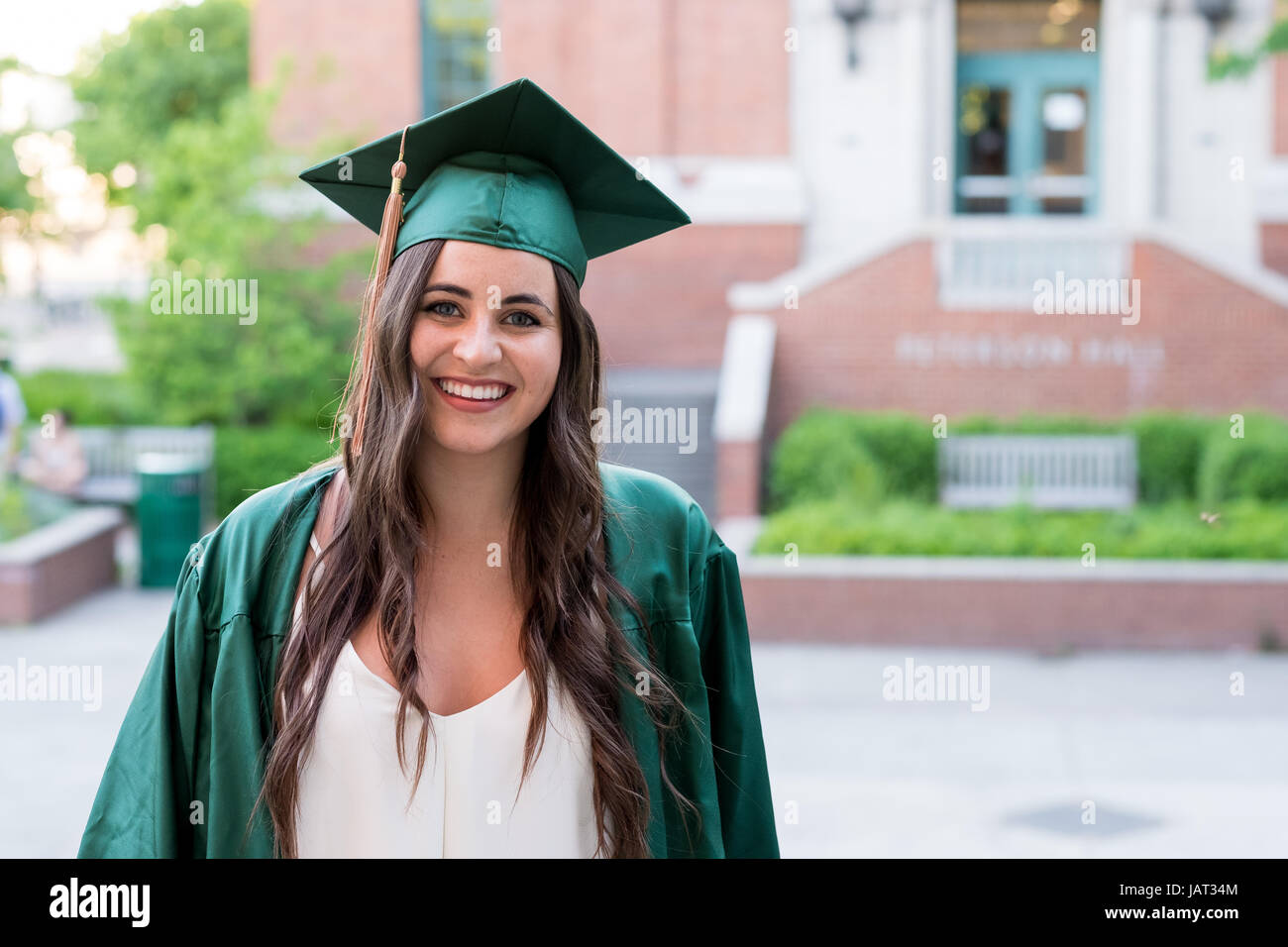 Pretty girl posing for a graduation photo on campus during her senior ...