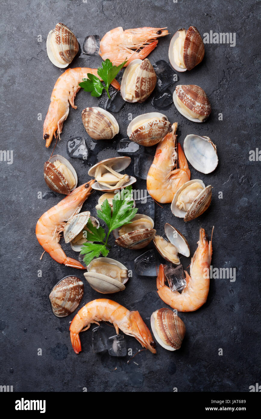 Fresh seafood on stone table. Scallops and shrimps. Top view Stock ...