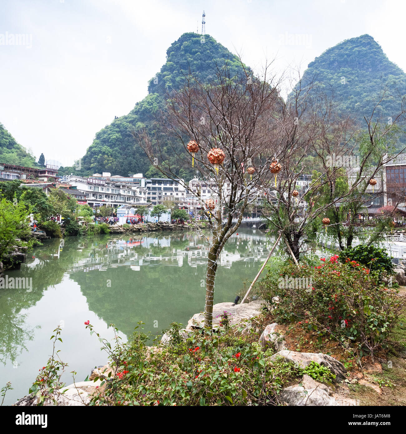 YANGSHUO, CHINA - MARCH 30, 2017: tree with lanterns on waterfront in ...