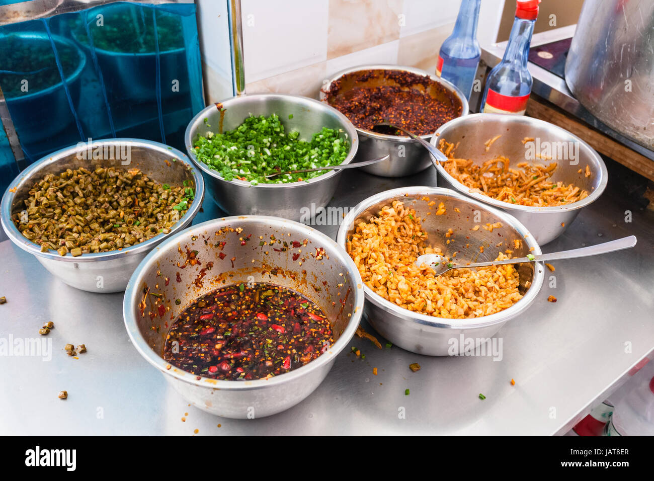 travel to China - bowls with seasonings, spices and toppings on kitchen ...