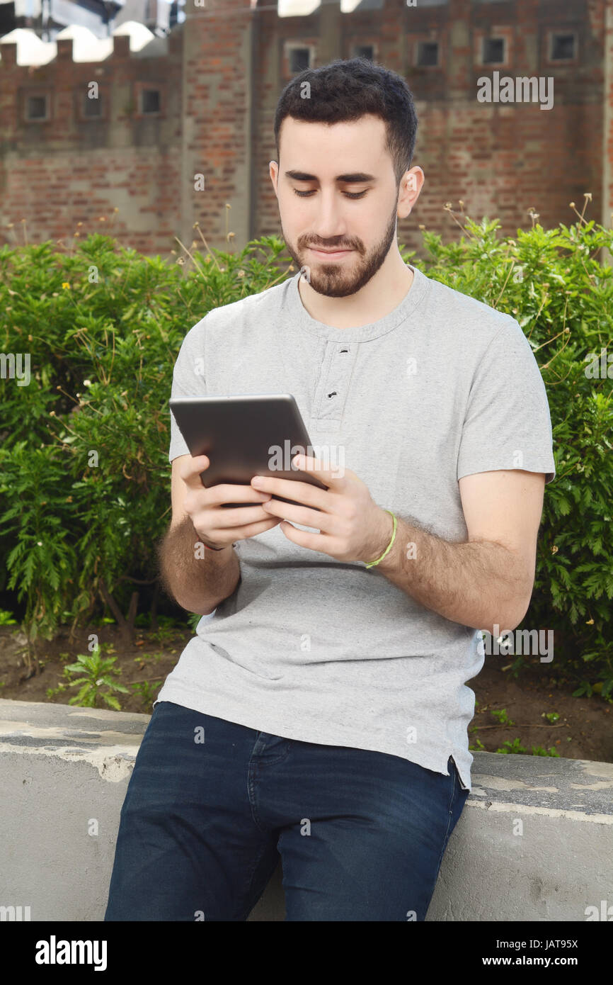 Attractive young man using digital tablet. Outdoors Stock Photo - Alamy