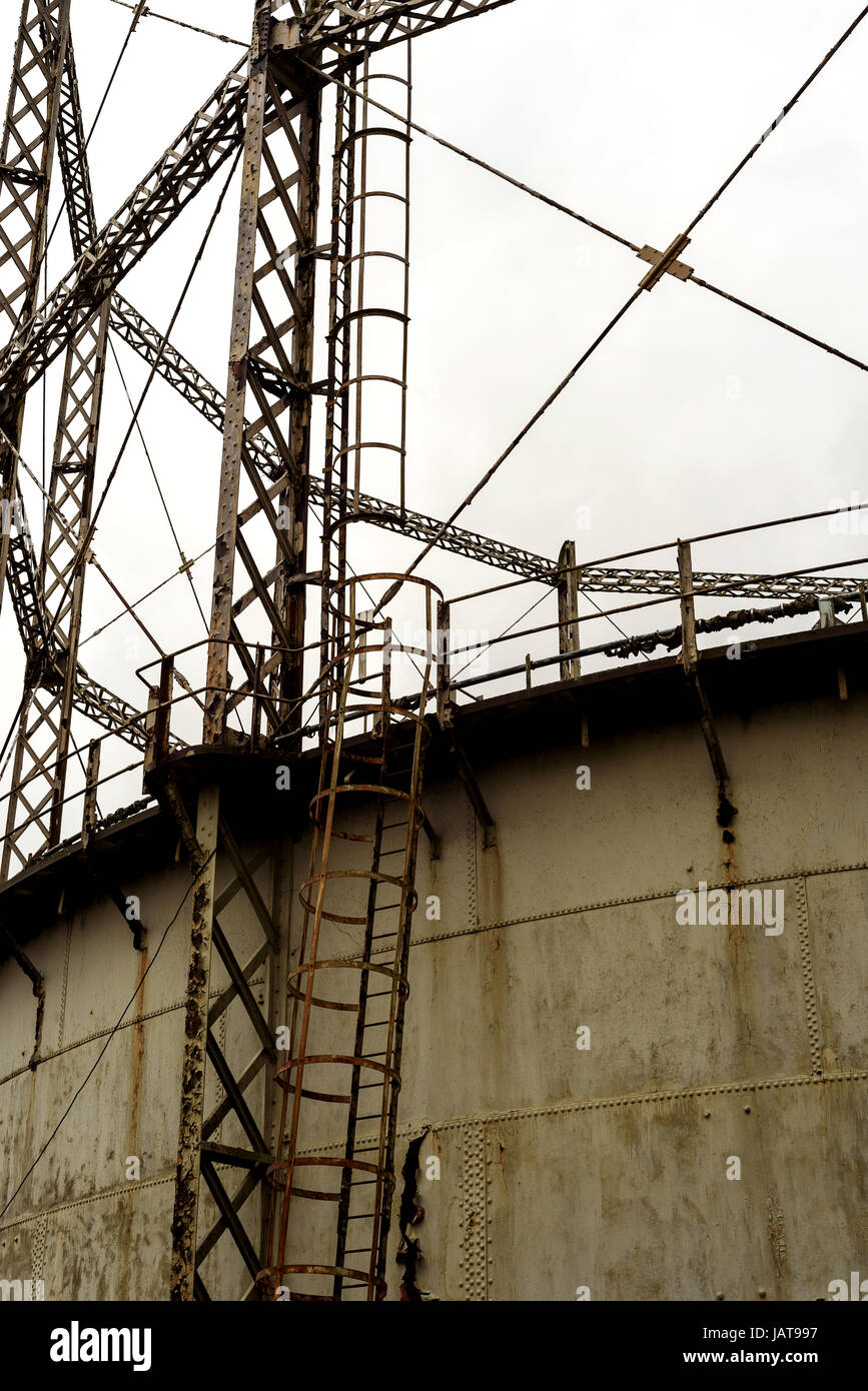 Old rusted metal railings on a disused water tower with an overcast sky ...