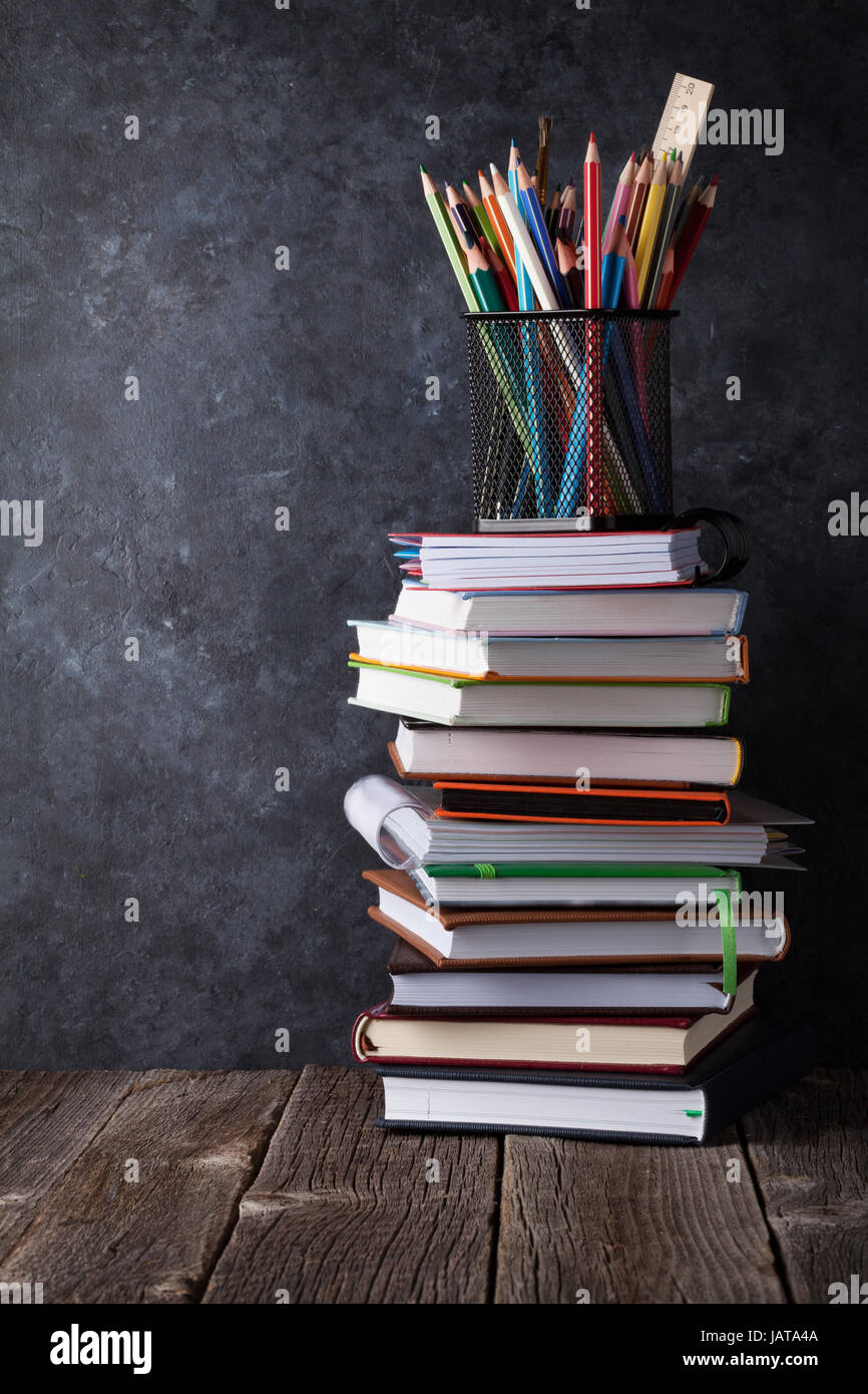 Books and supplies in front of classroom chalk board. Back to school ...