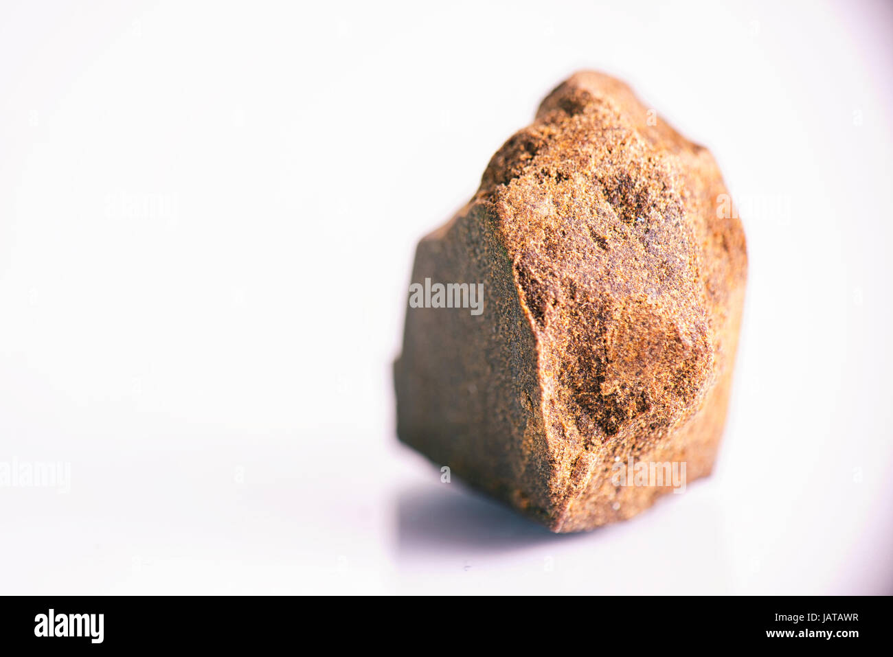 Macro detail of a single piece of cannabis extraction aka hashish ...