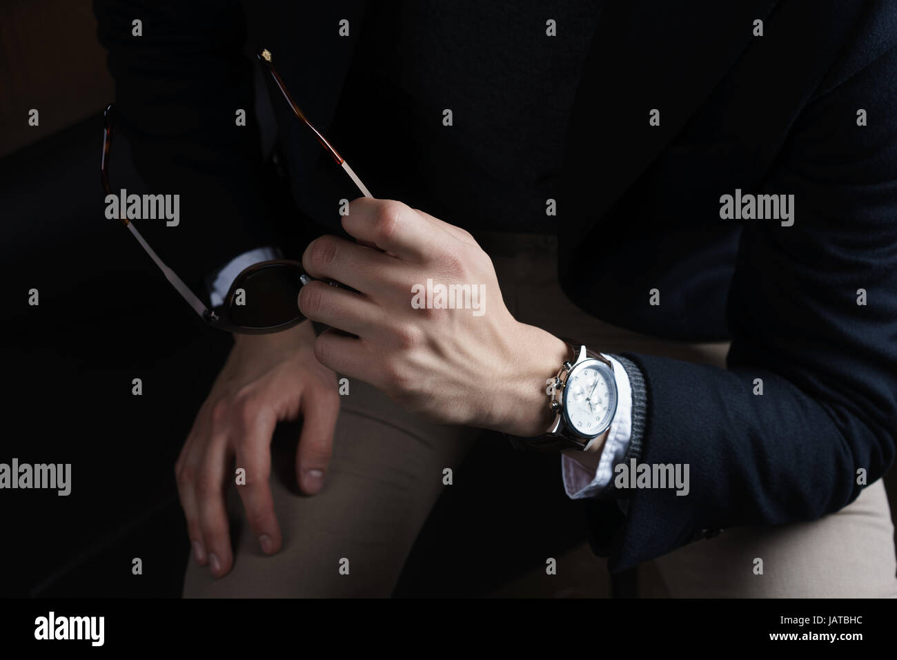 Closeup photo of man's hand with watch, holds eyeglasses. Horizontal ...