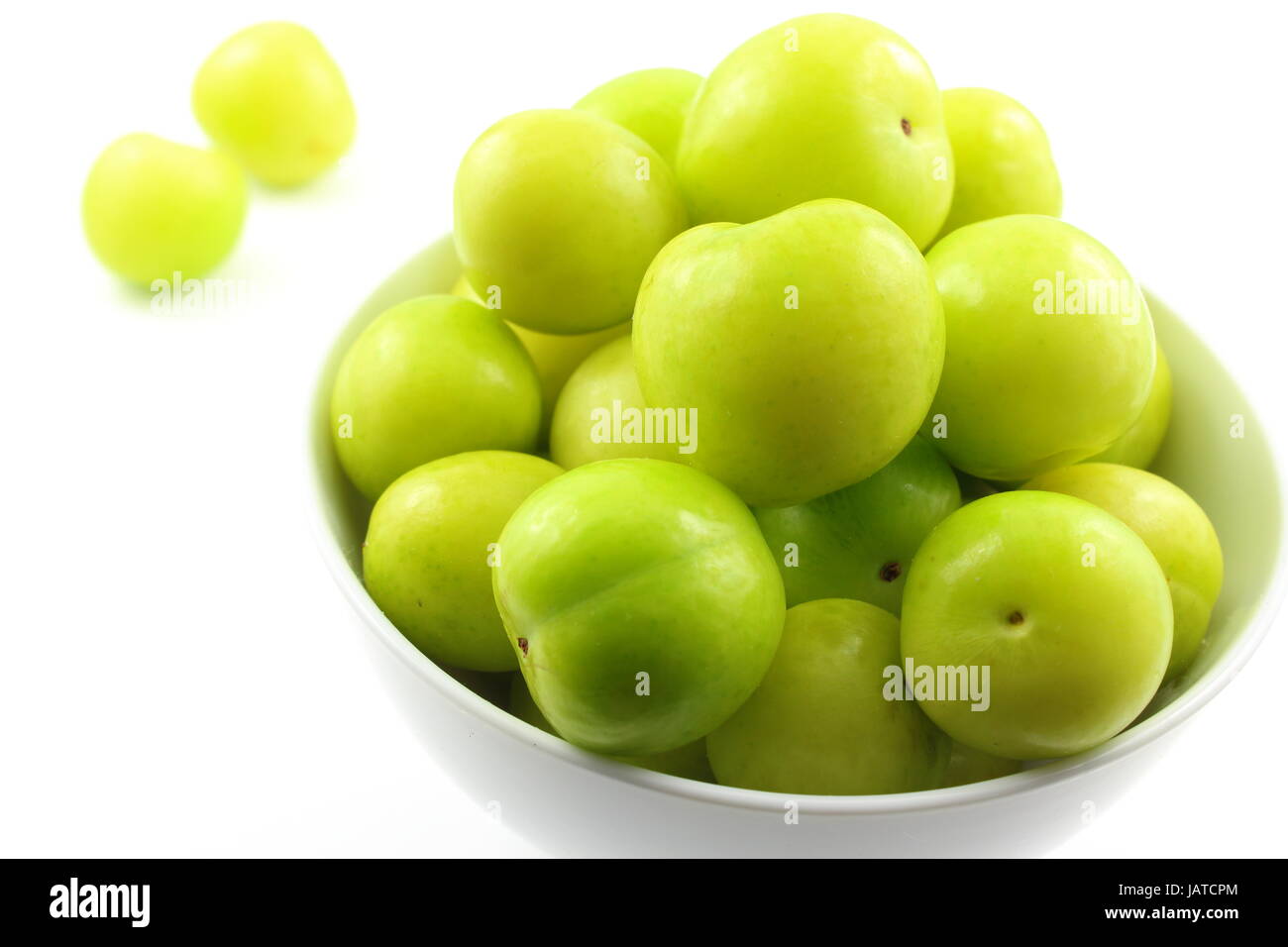 composition of fresh turkish can erik plum fruits in a small white bowl ...