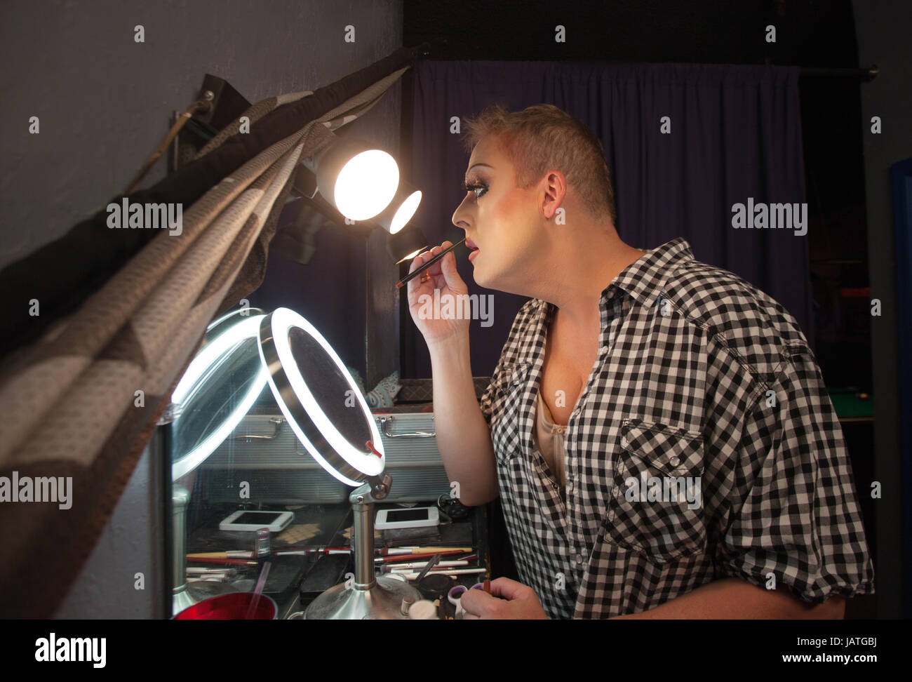Serious male drag queen performer using lipstick pencil Stock Photo - Alamy