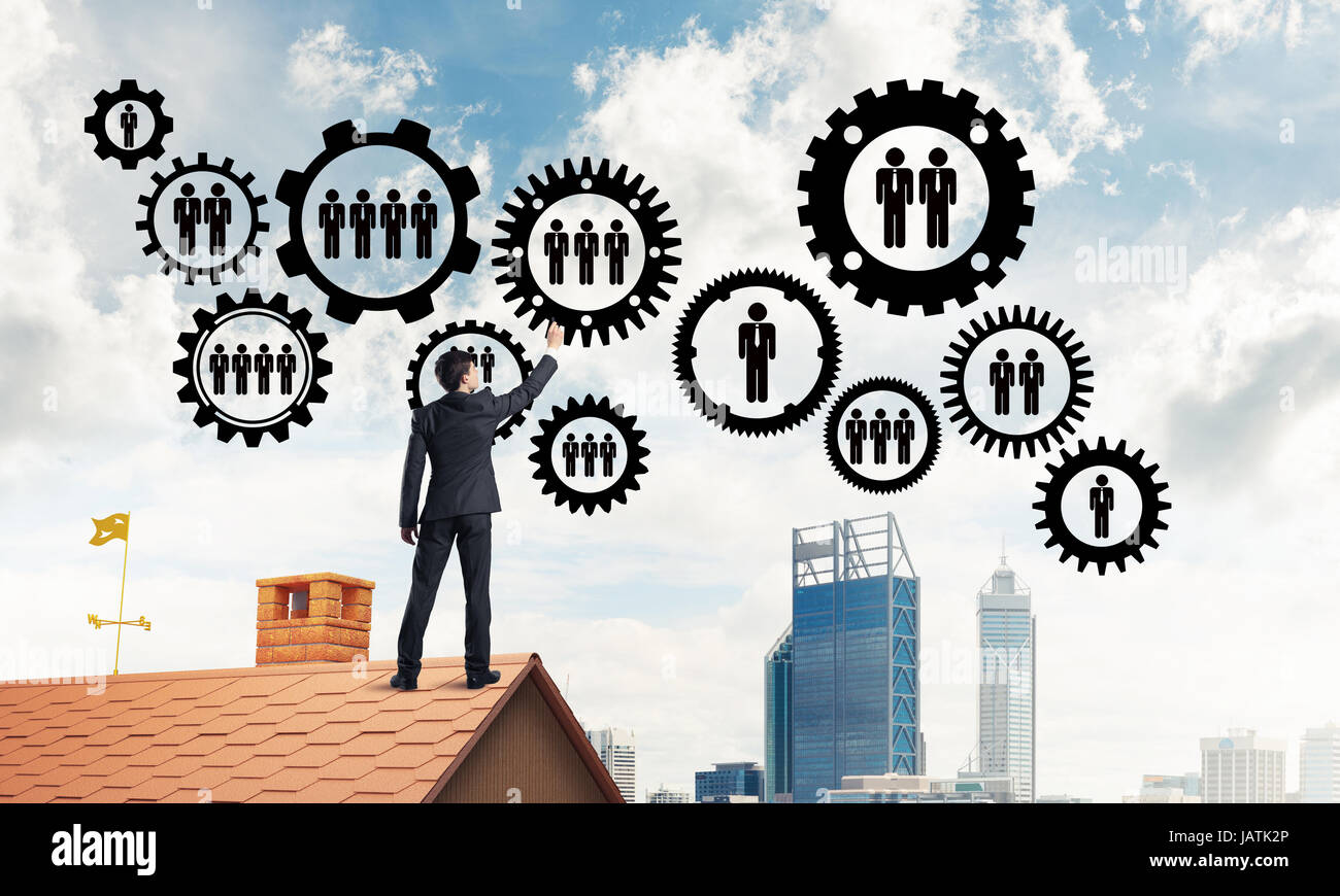Businessman on house roof presenting teamwork and connection con Stock ...