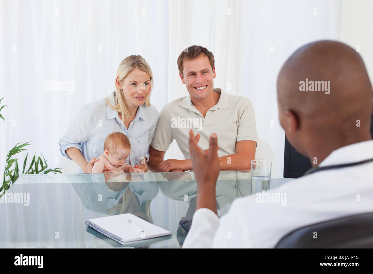 Parents with their baby seeing the doctor Stock Photo - Alamy