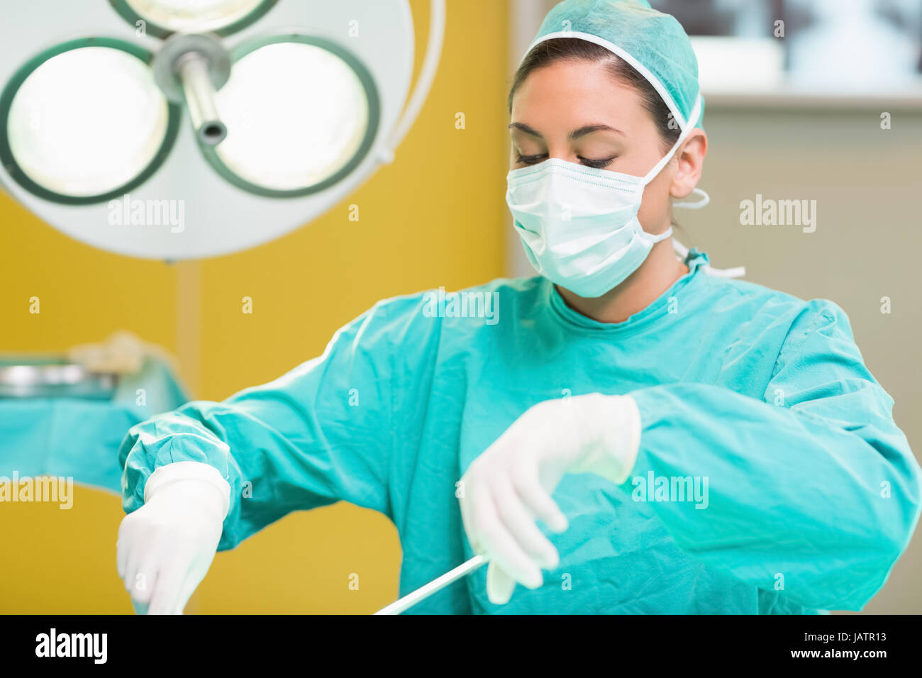 Female surgeon using surgical tools in operating theater Stock Photo ...