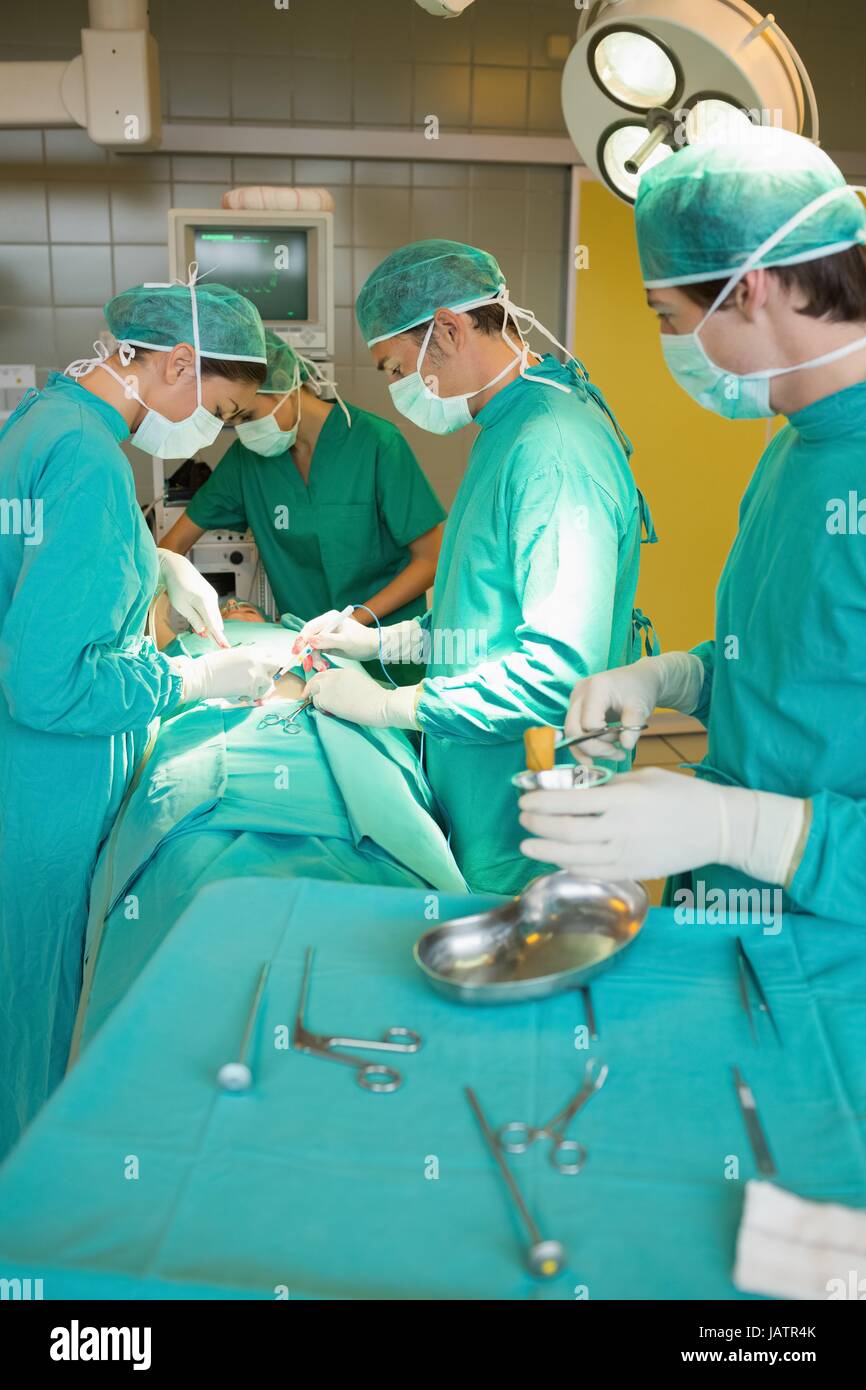 Serious surgeon team operating a patient Stock Photo - Alamy